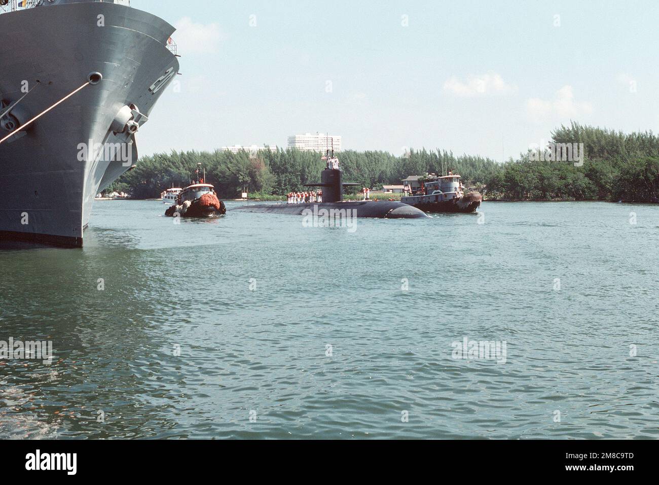 Commercial tugs escort the nuclear-powered attack submarine USS ...