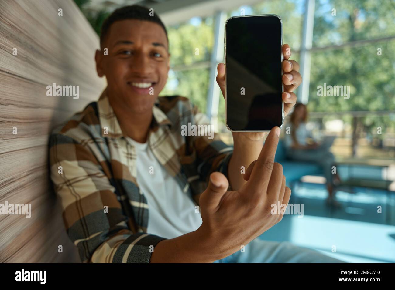 Happy African American guy pointing finger at mobile phone screen Stock ...