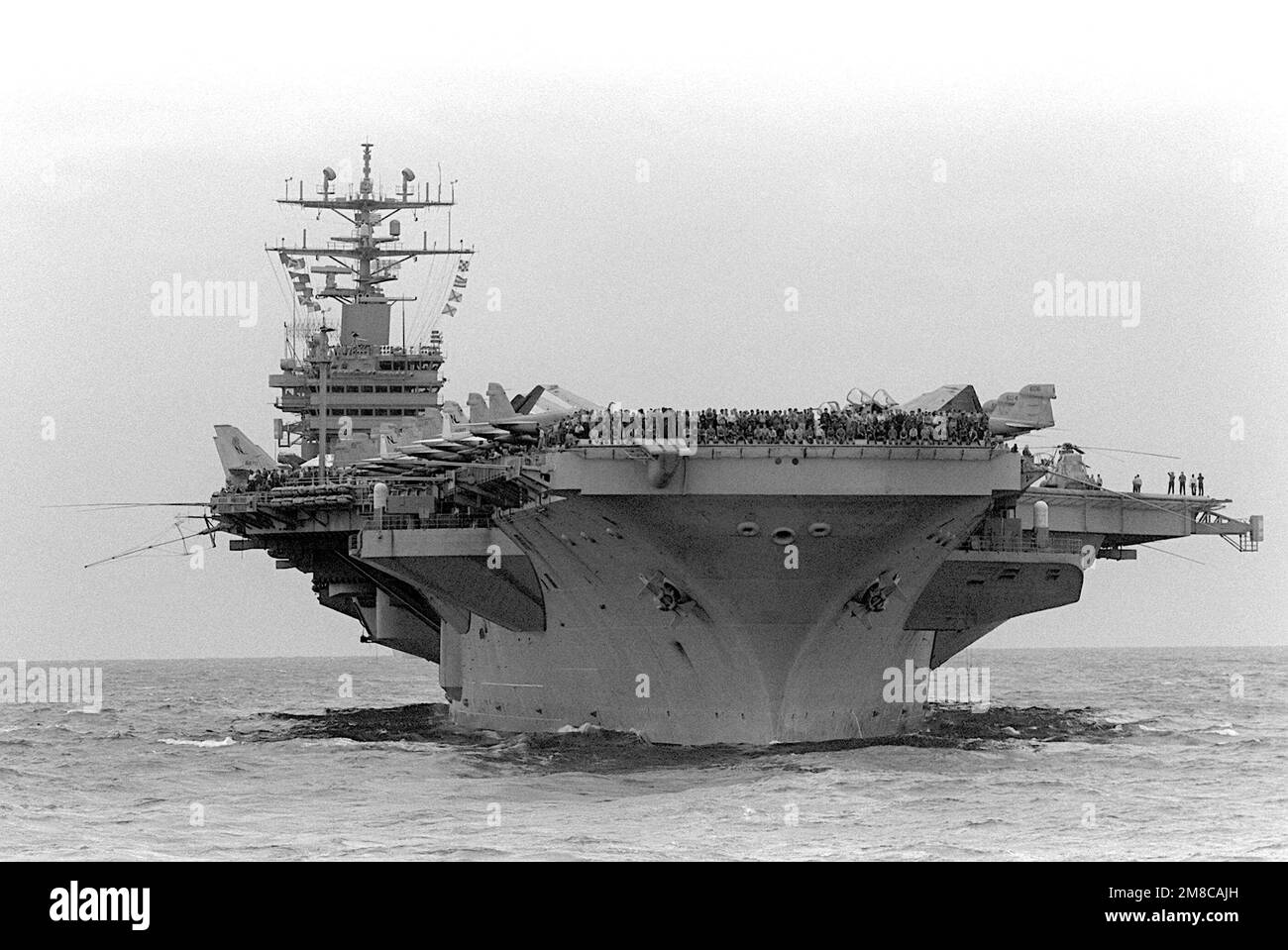 Crewmen line the bow of the nuclear-powered aircraft carrier USS CARL ...