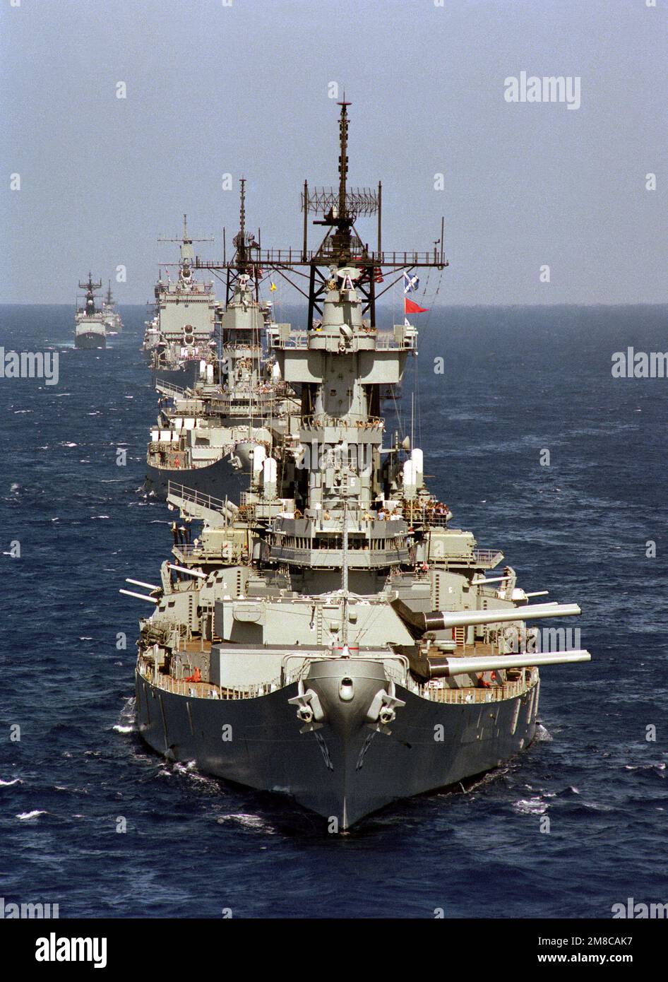 A bow on view of the battleship USS NEW JERSEY (BB-62) leading the ...