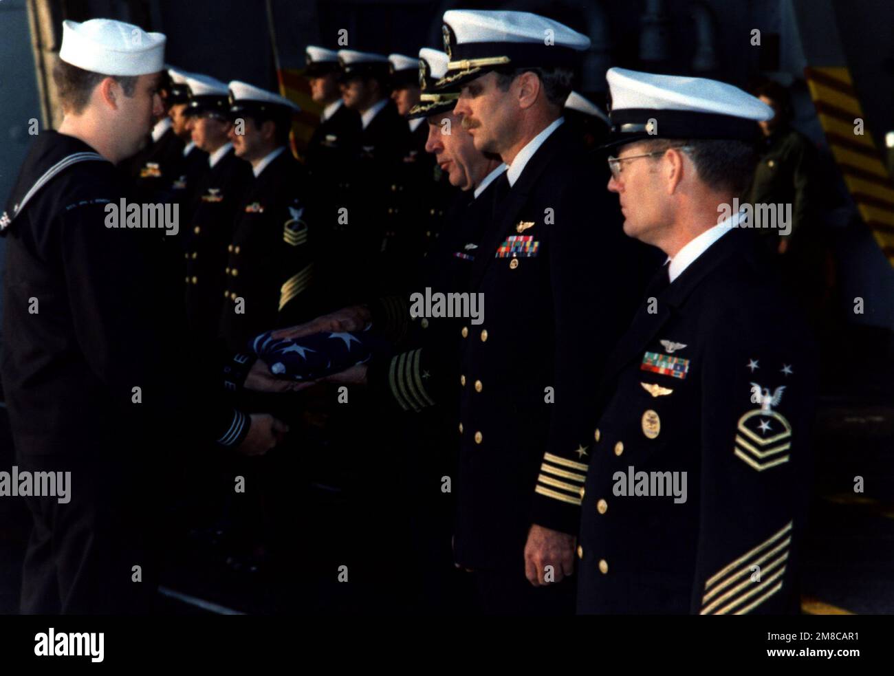 Captain Herbert A. Browne, Commanding Officer, accepts the flag from ...