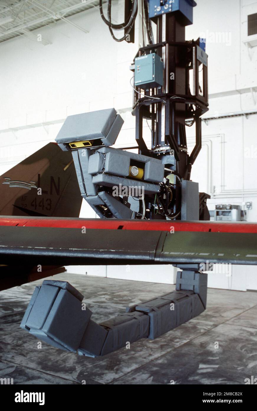 A maneuverable X-ray machine inspects the wing of an F-111 aircraft in ...