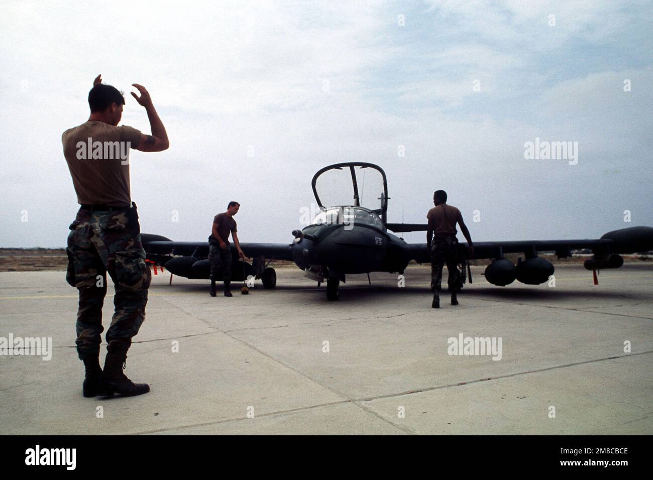 A ground crew member directs the pilot of a 24th Tactical Air Support ...