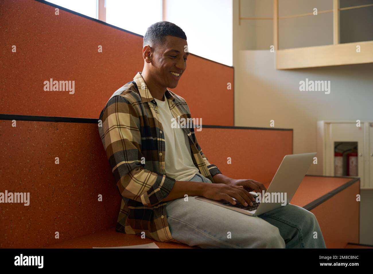 Happy male student is working with laptop Stock Photo - Alamy
