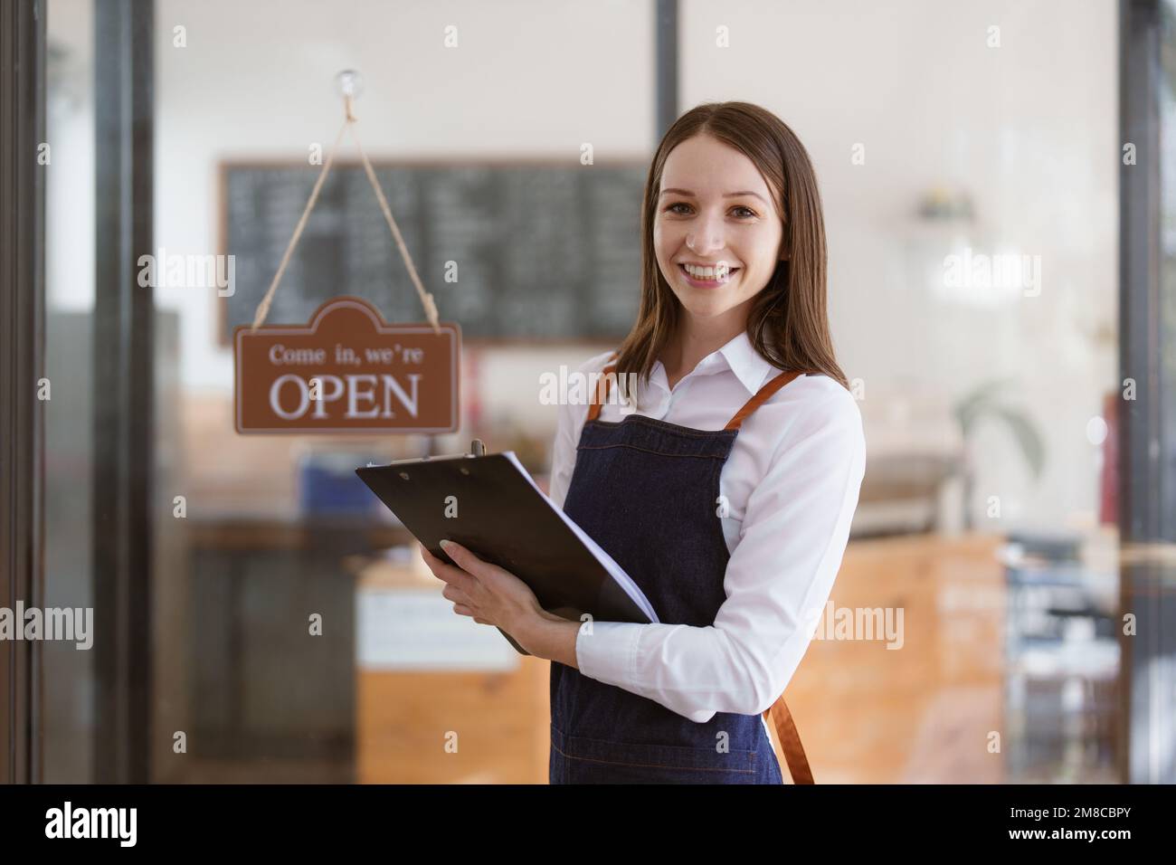 Young Female manager in restaurant with tablet. Woman coffee shop owner ...