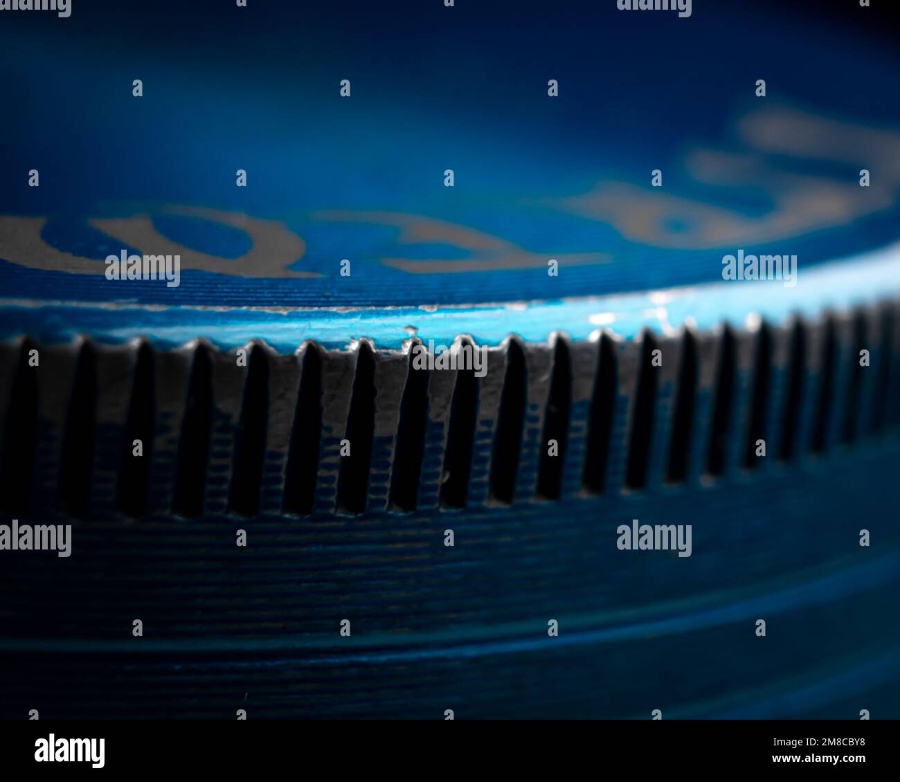A macro shot of vertical grooves on the edge of a circular metal Stock ...