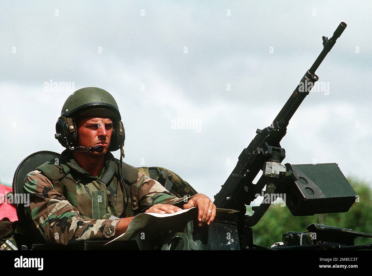 A Marine crewman aboard a LAV-25 Light Armored Vehicle (LAV) consults a ...