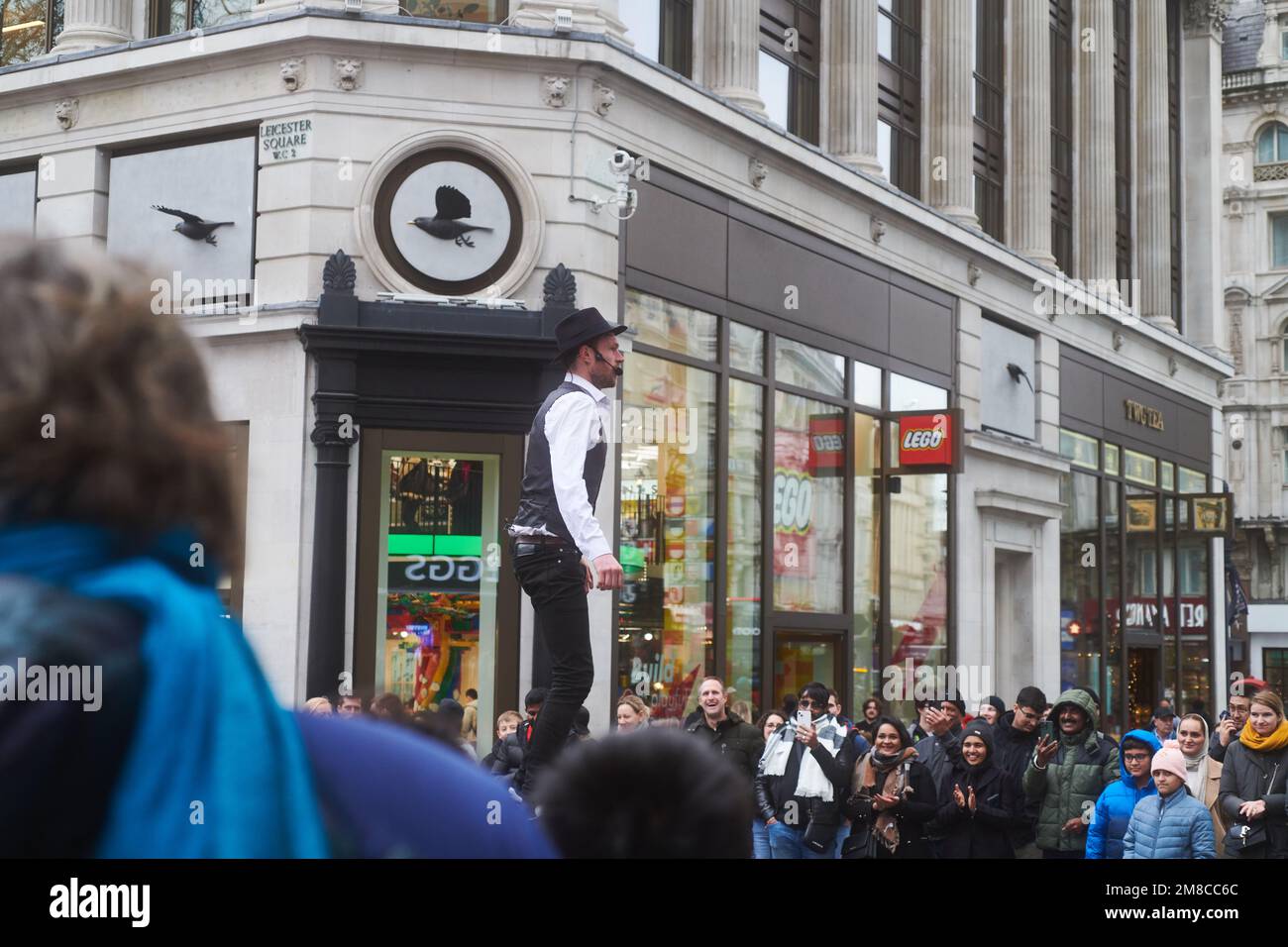 A street performer doing acrobatics in front of a crowd in the city ...