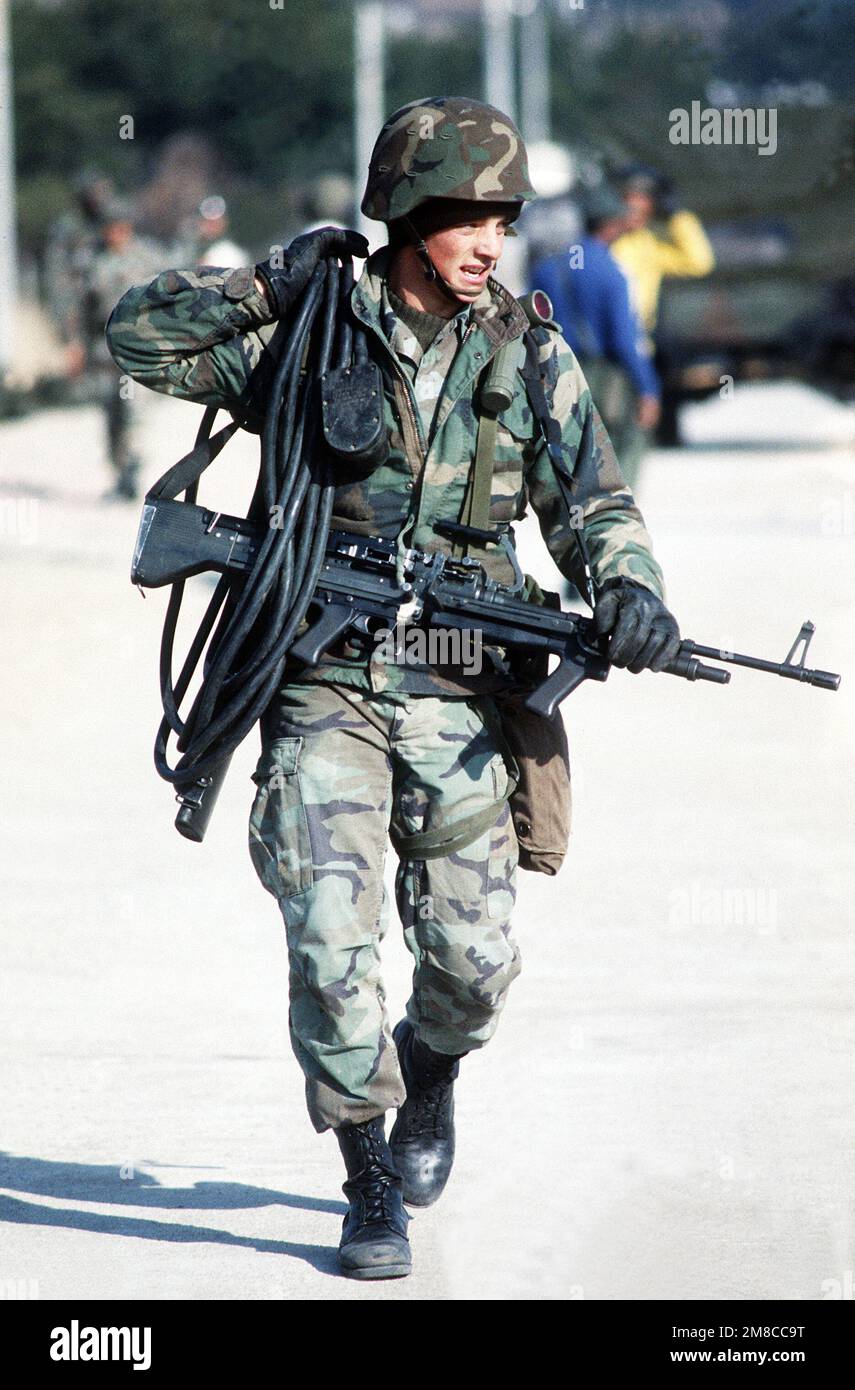 A Marine armed with an M-60E3 7.62mm machine gun carries an electrical ...