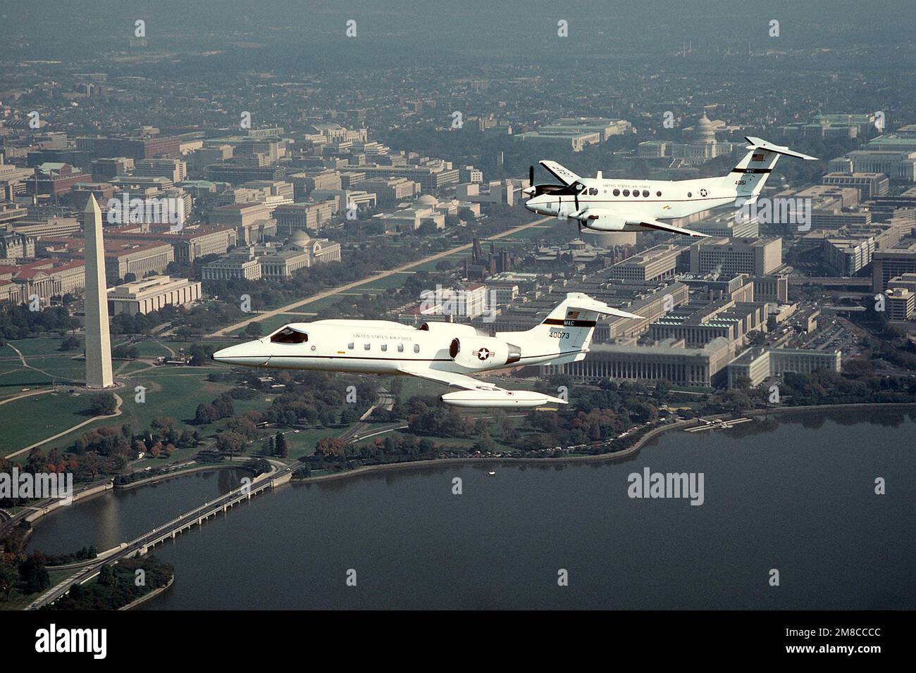 An air-to-air left side view of a C-21 aircraft and a C-12 Huron ...