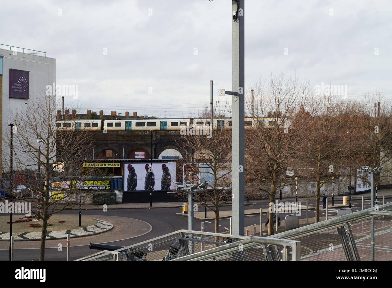 Tube train passing by on the overhead rail bridge next to the Arsenal ...
