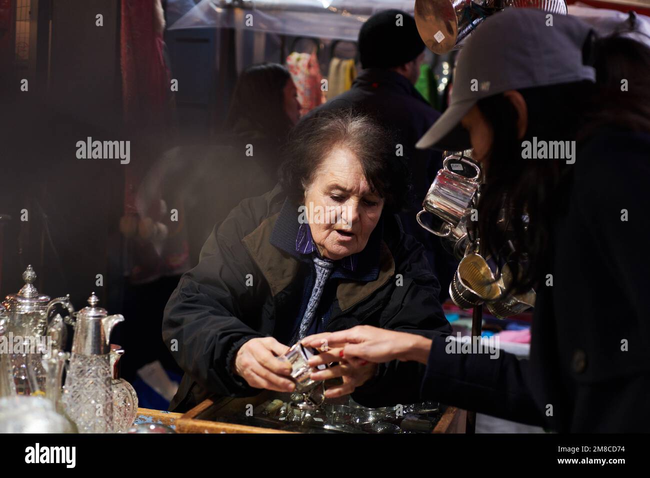 Elderly sales lady selling silver at Portobello Market in Notting Hill ...