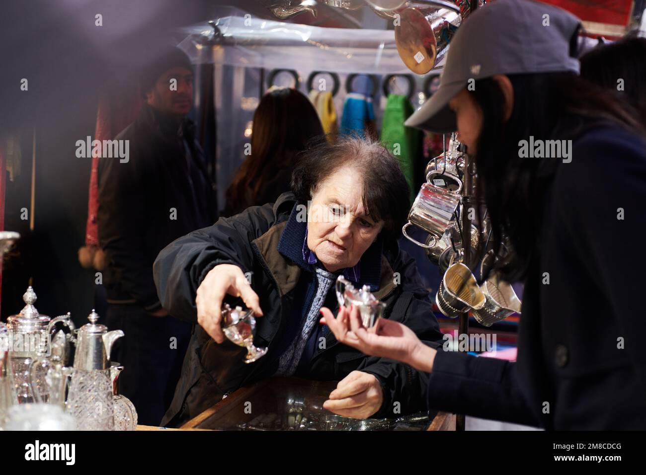Elderly sales lady selling silver at Portobello Market in Notting Hill ...