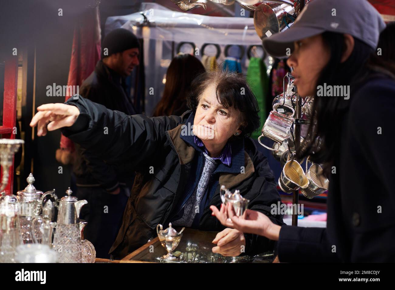 Elderly sales lady selling silver at Portobello Market in Notting Hill ...