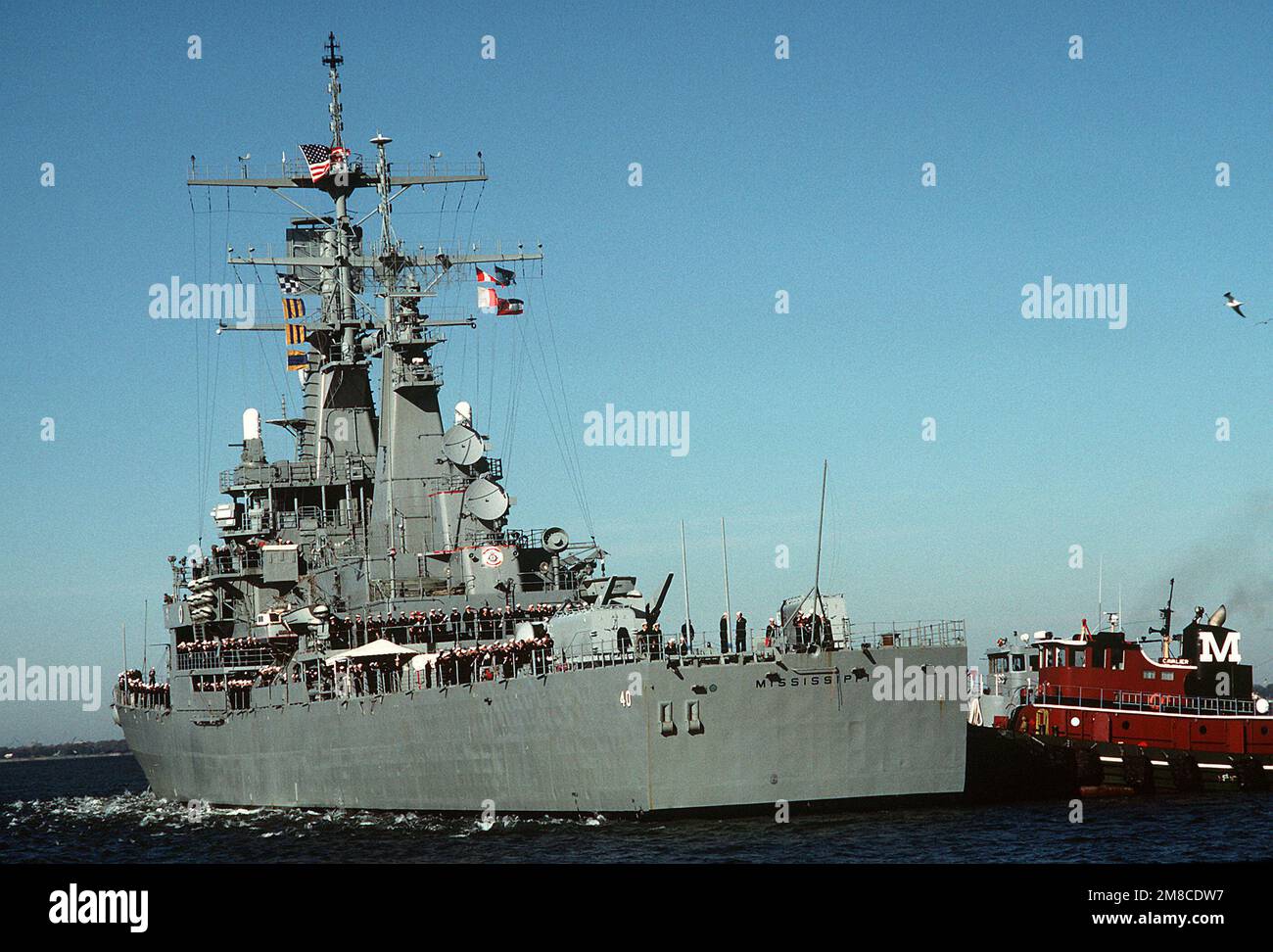 A tug helps the nuclear-powered guided missile cruiser USS MISSISSIPPI ...