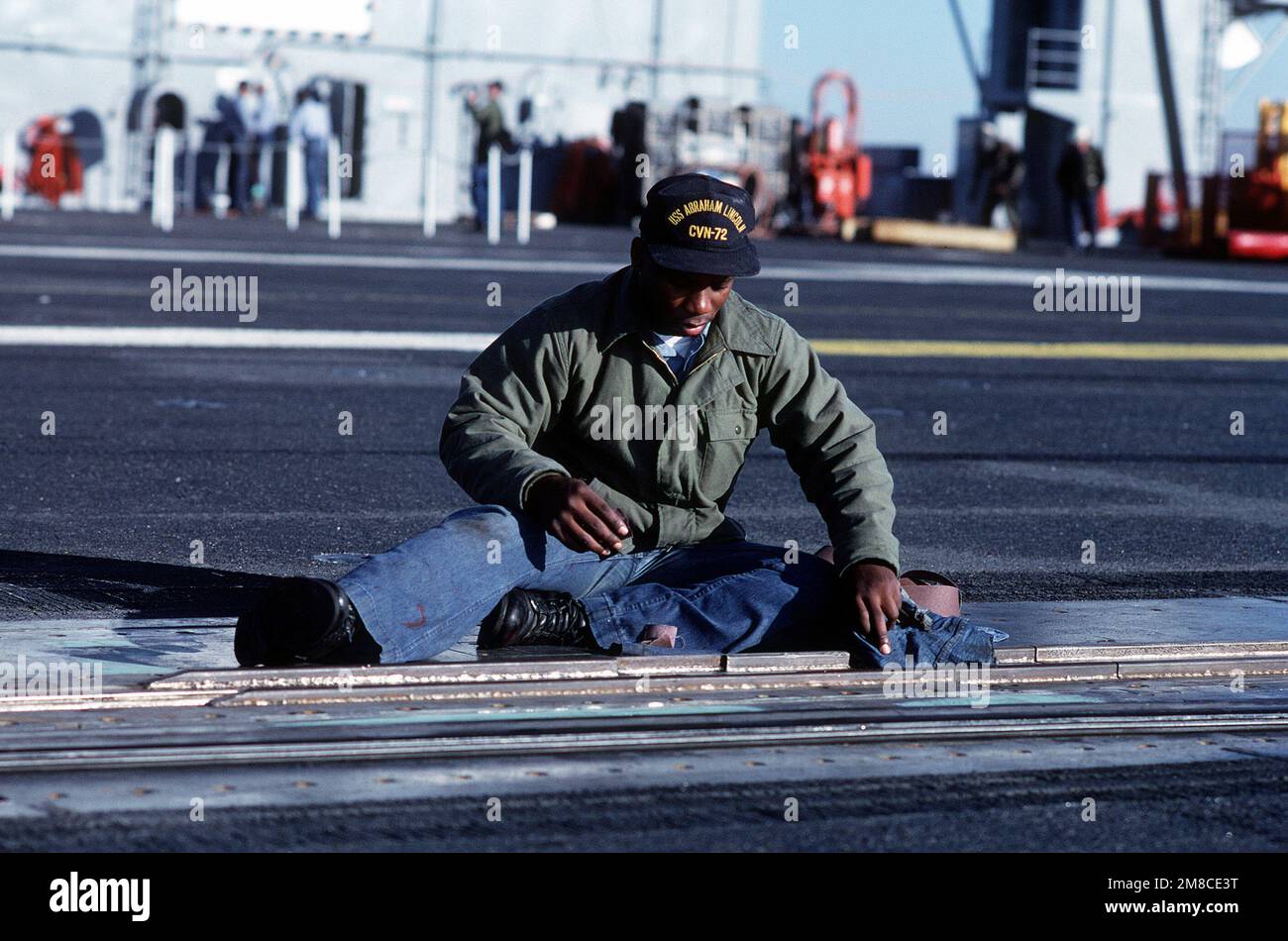 A sailor cleans a catapult track on the nuclear-powered aircraft ...
