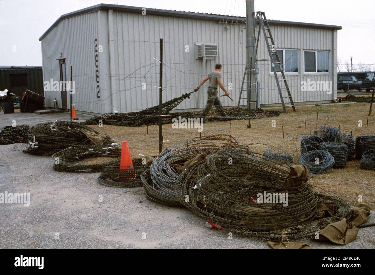 A member of the 8th Security Police Squadron prepares to camouflage ...