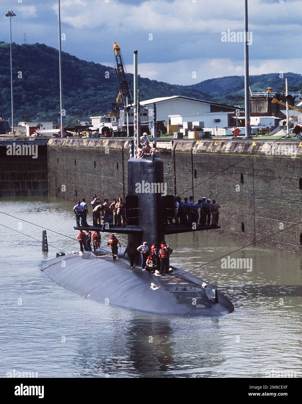 Crew members stand on the sail and diving planes of the nuclear-powered ...