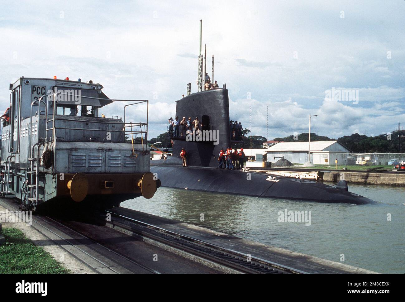 Crew members stand on the sail and diving planes of the nuclear-powered ...
