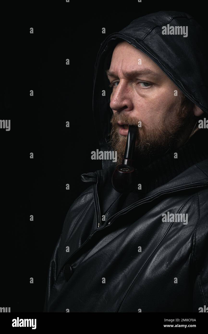 Portrait of a Bearded man in Black Rain Jacket Smoking a Pipe Stock ...