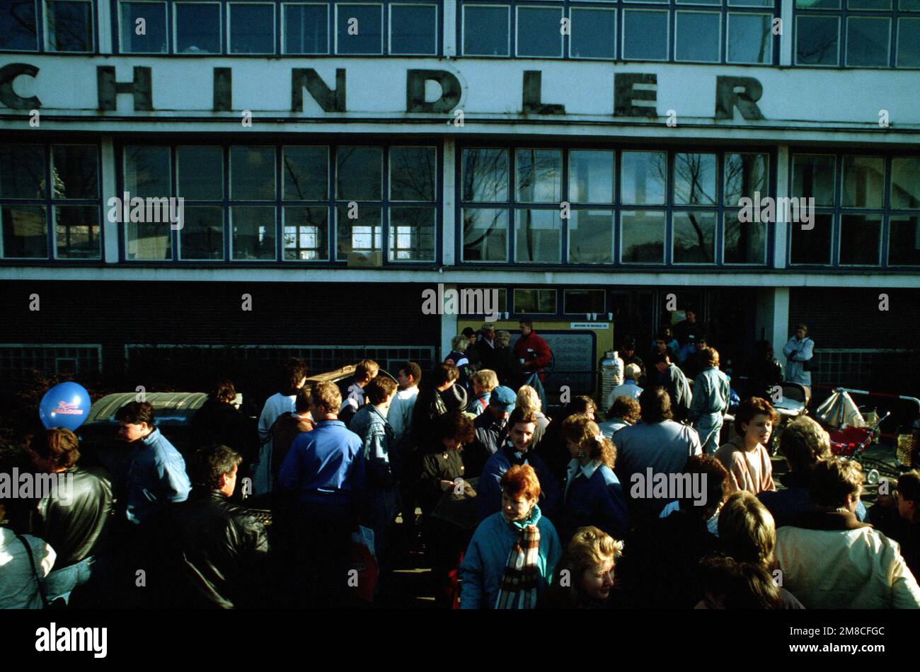 A crowd of East German refugees gathers outside the refugee center in ...