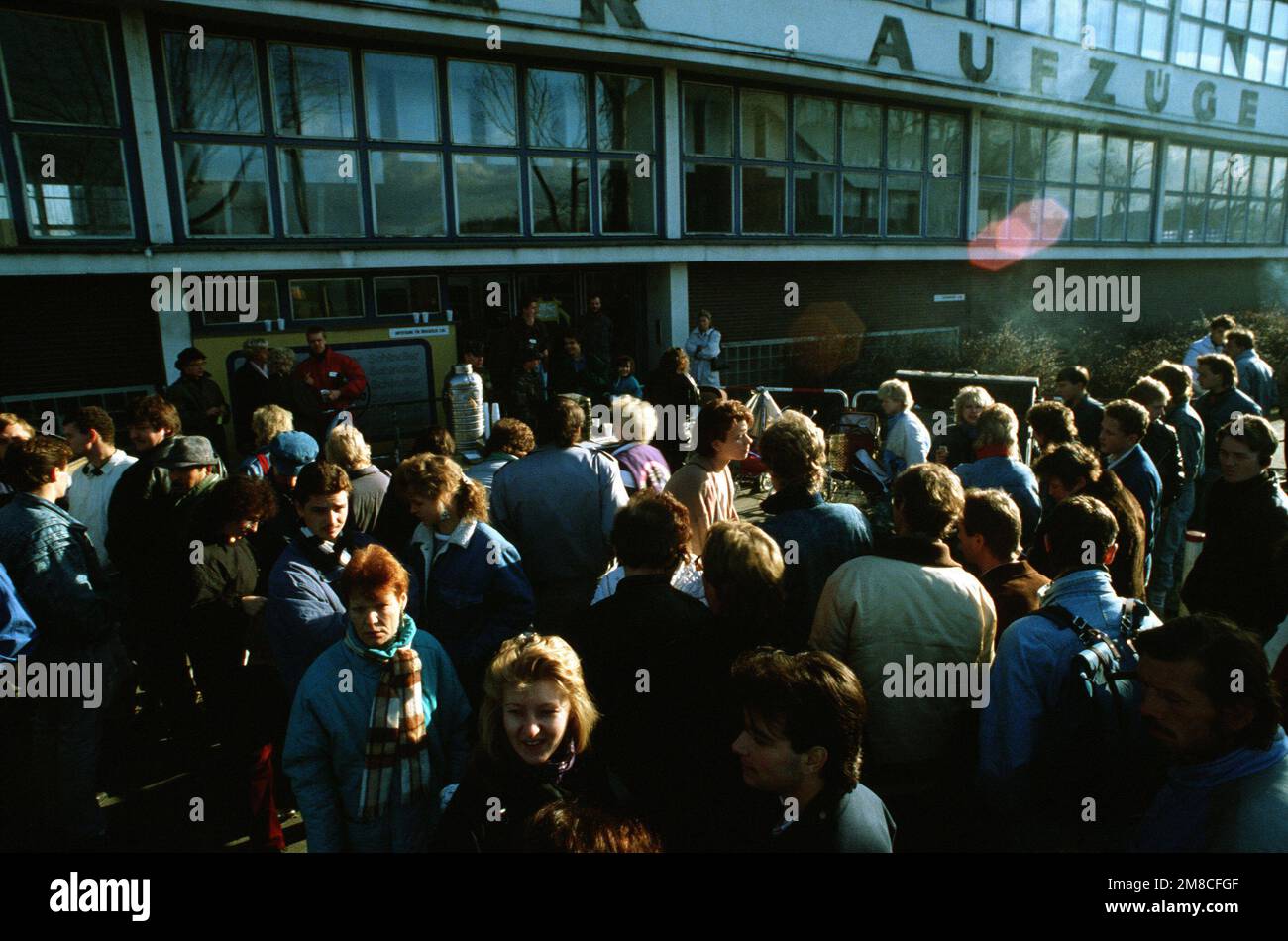 A crowd of East German refugees gathers outside the refugee center in ...