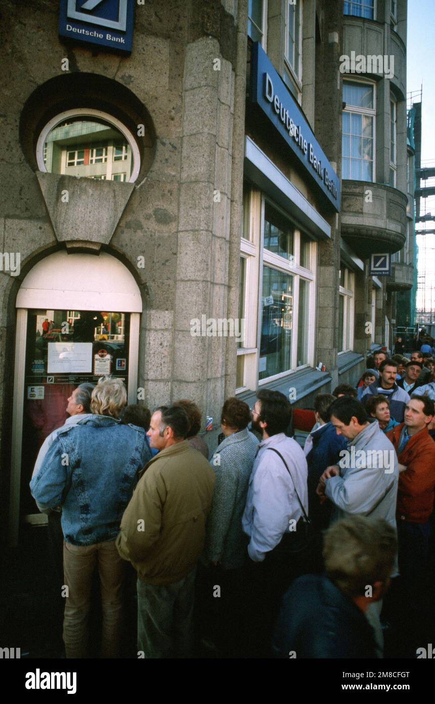 East German refugees line up at a bank to receive an allotment of 100 ...