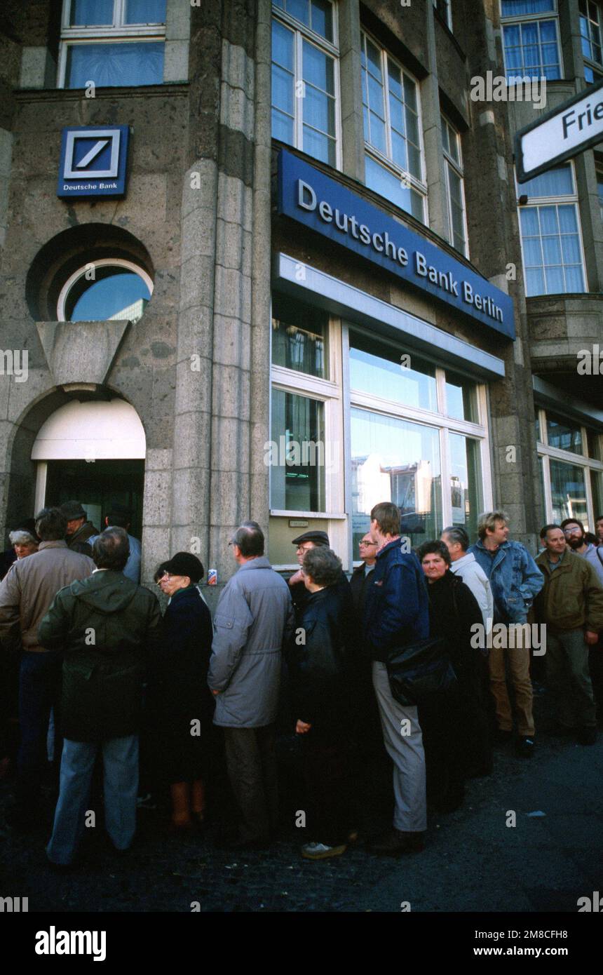 East German refugees line up at a bank to receive an allotment of 100 ...