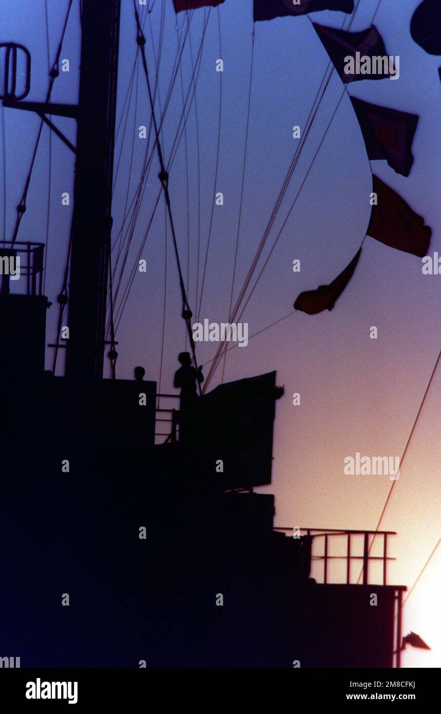 A crew member signals with semaphore flags aboard the fleet oiler USNS ...