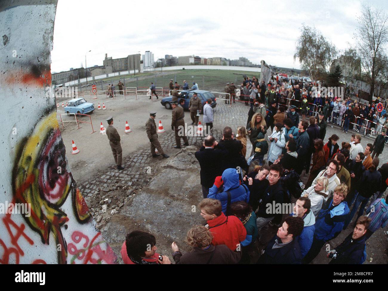 A crowd of West German citizens gathers at the newly created opening in ...