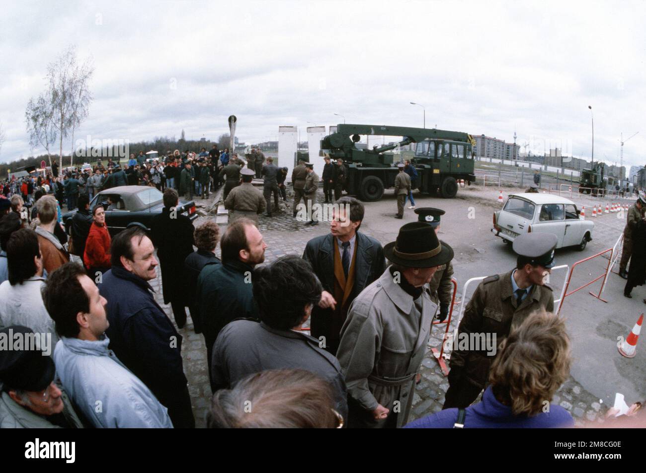 A crowd gathers as cars pass through the newly created opening in the ...
