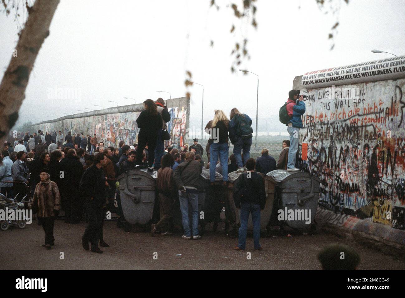 A crowd of West German citizens gathers at the newly created opening in ...
