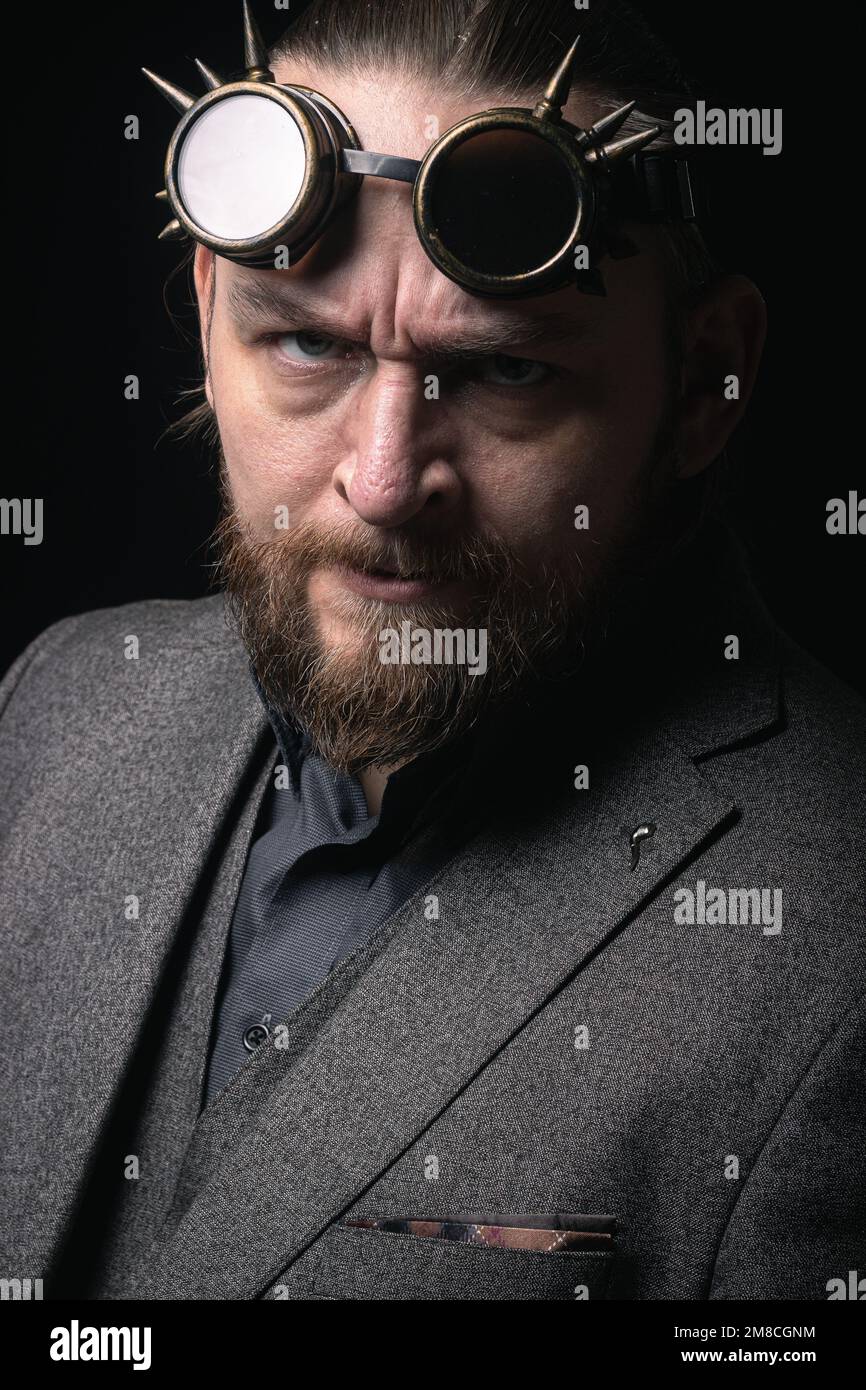 charismatic man in a classic suit and steampunk goggles on a black ...