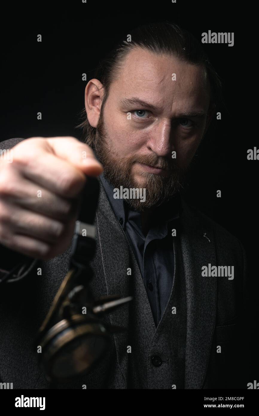 charismatic man in a classic suit and steampunk goggles on a black ...