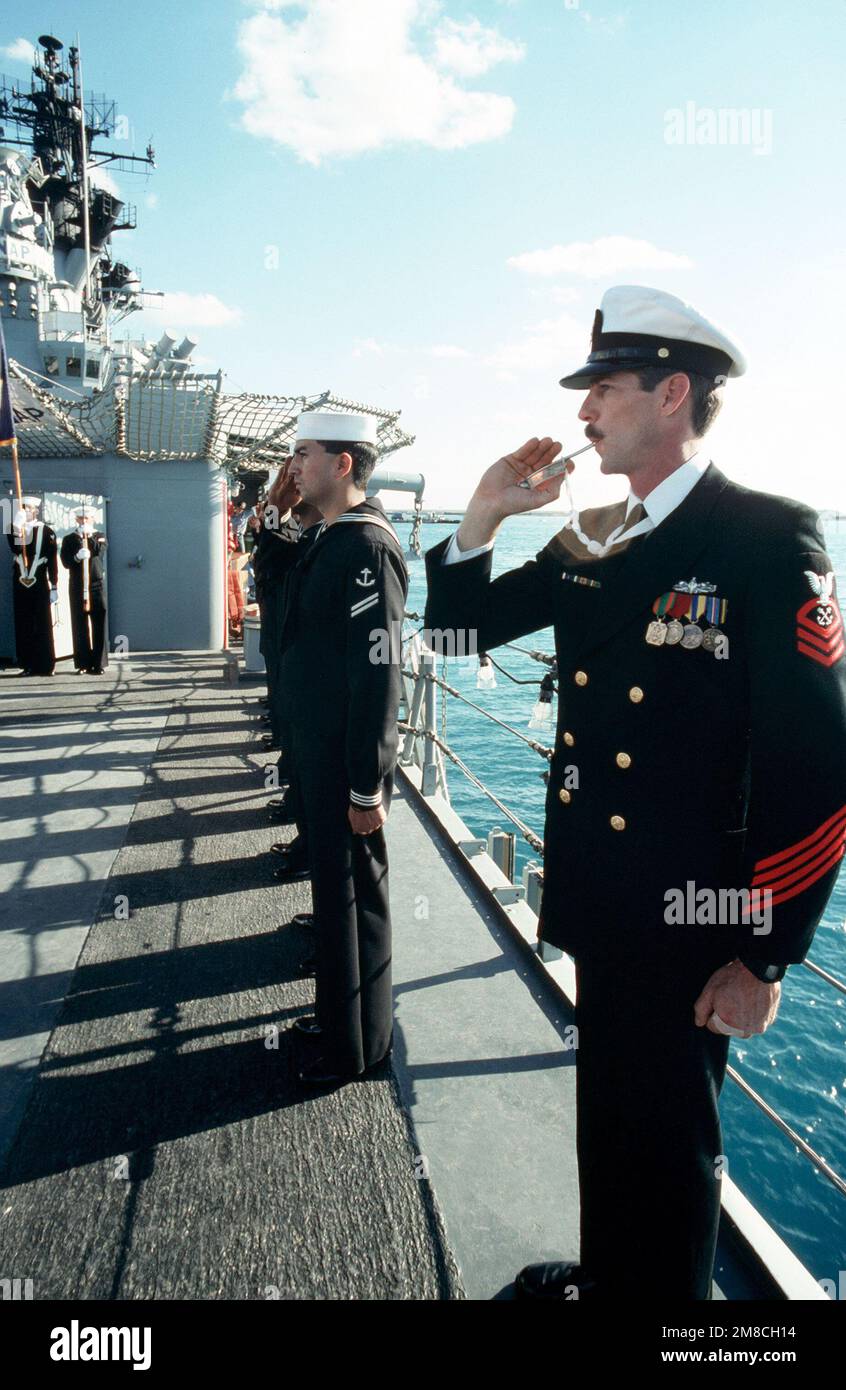 Crew members salute as the chief boatswain's mate rehearses piping ...