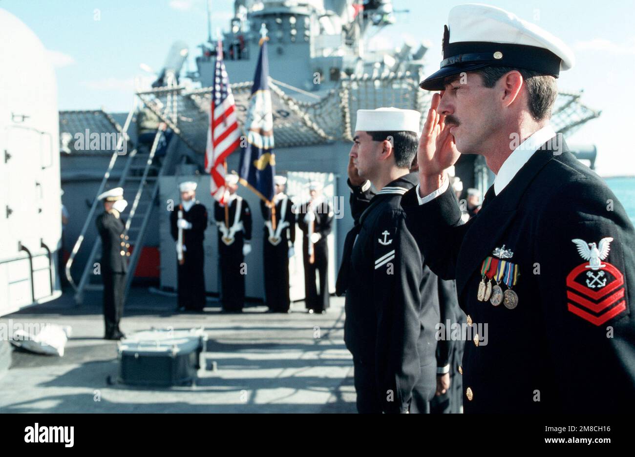 The chief boatswain's mate and crew members salute as the colors are ...