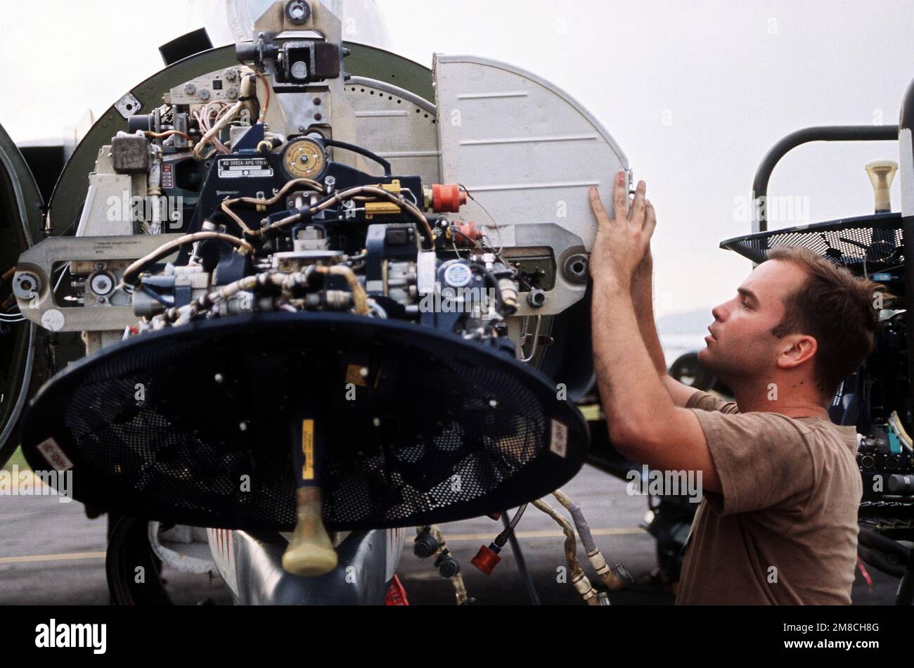 A technician works on the AN/APQ-120(V) fire control radar in the nose ...
