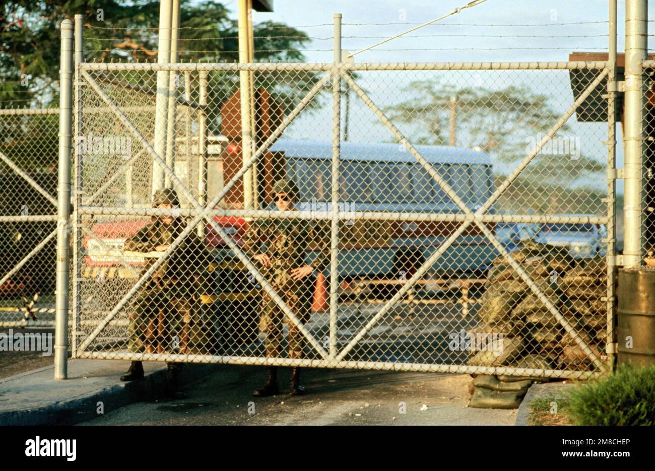 Security personnel guard a closed pedestrian gate to the base. A ...