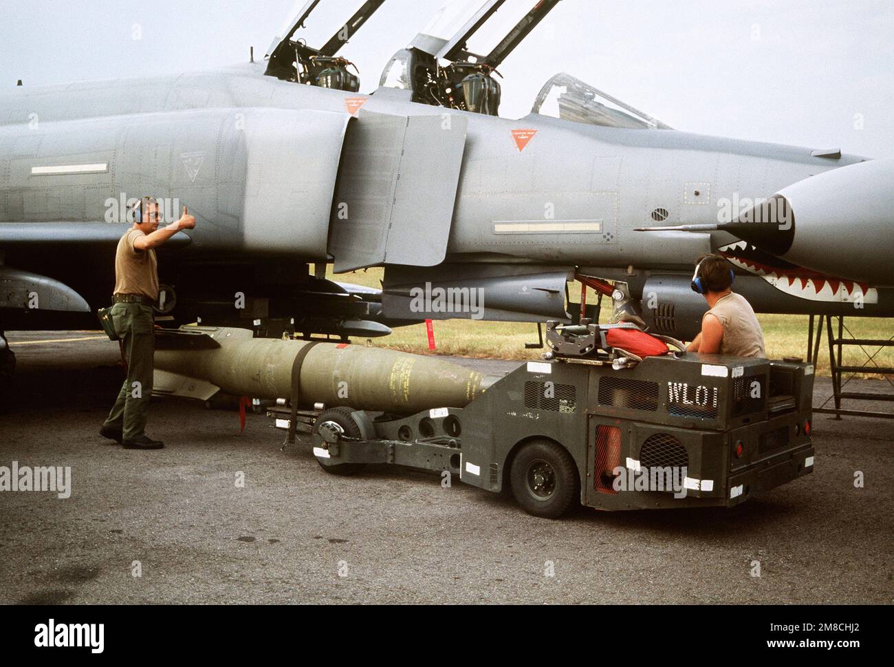 An airman uses an MJ-1 weapons loader to position a GBU-10 2,000-pound ...