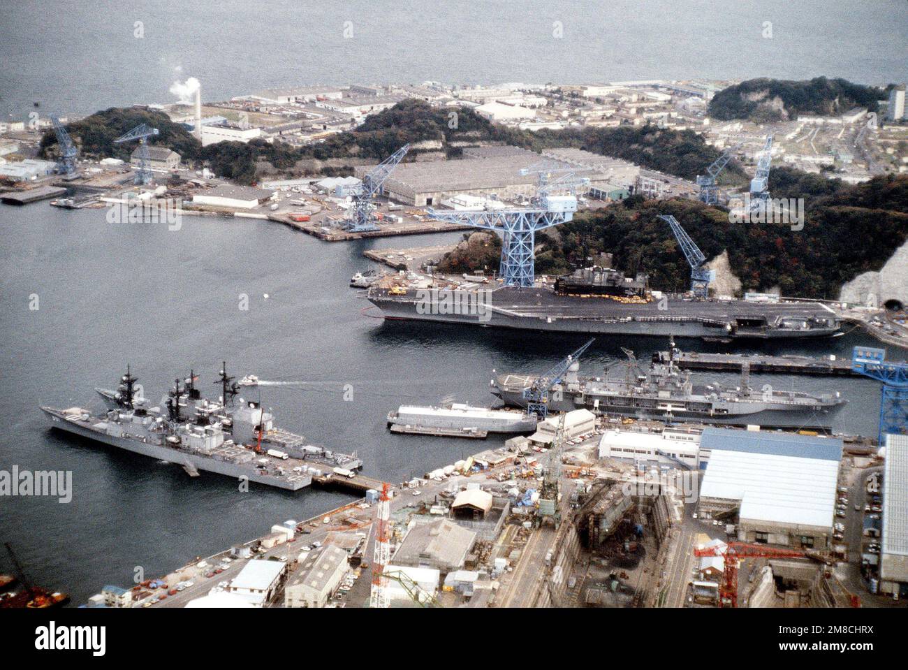An aerial view of docked warships. Top to Bottom: the aircraft carrier ...