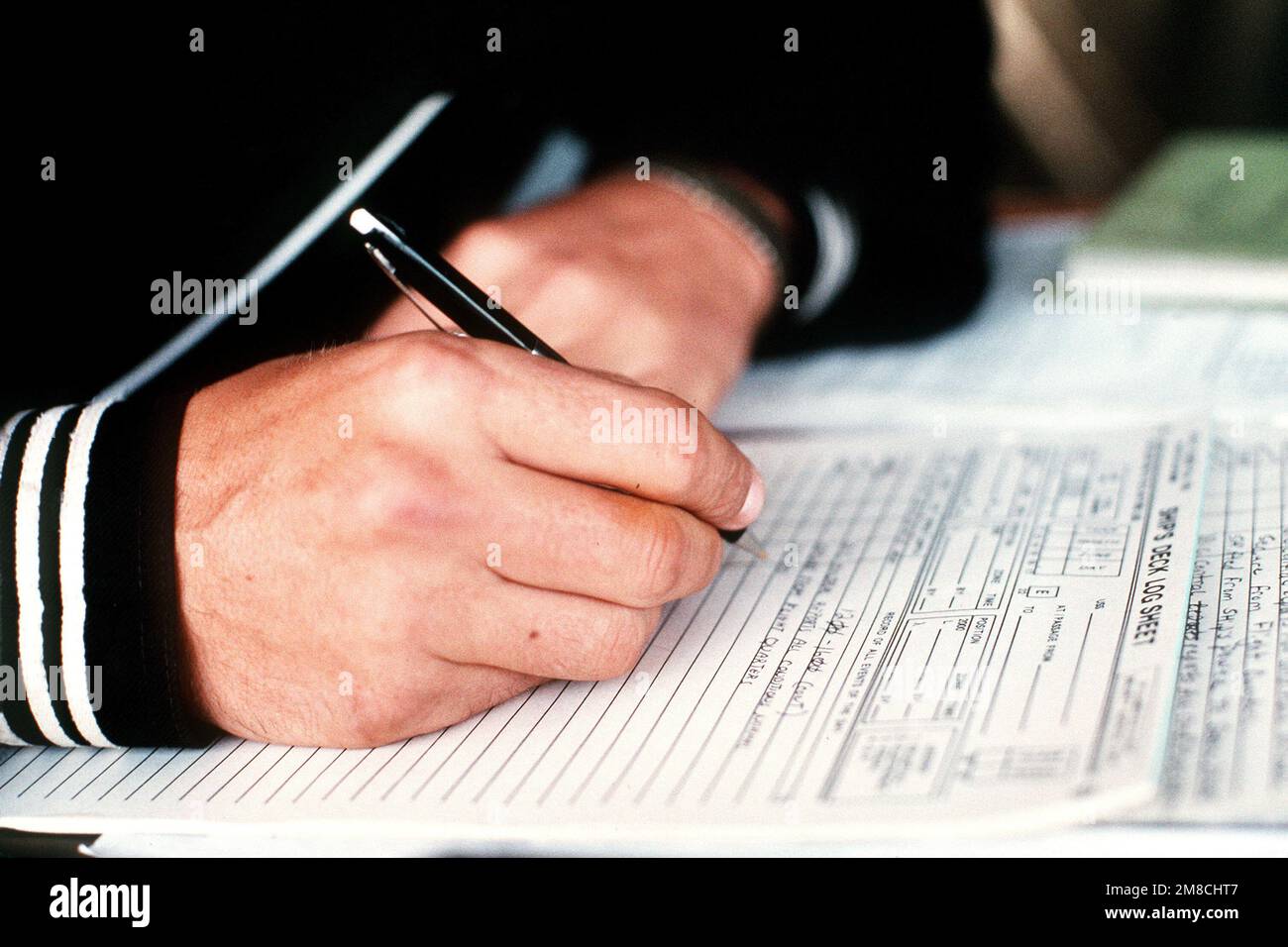 An entry is made in the ship's deck log aboard the guided missile ...