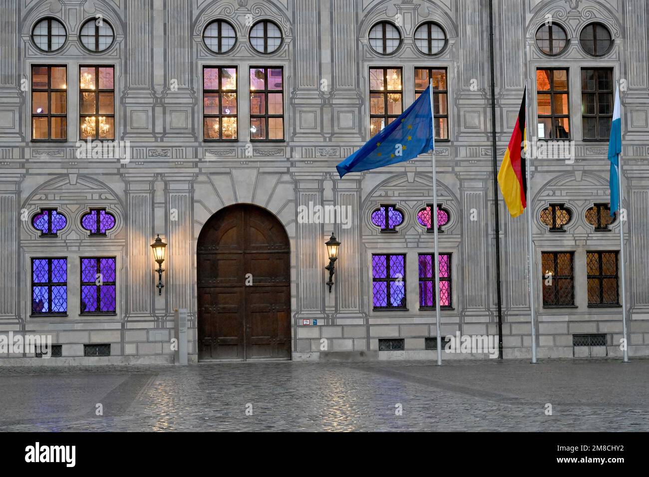13 January 2023, Bavaria, Munich: Flags are seen in the rain outside ...