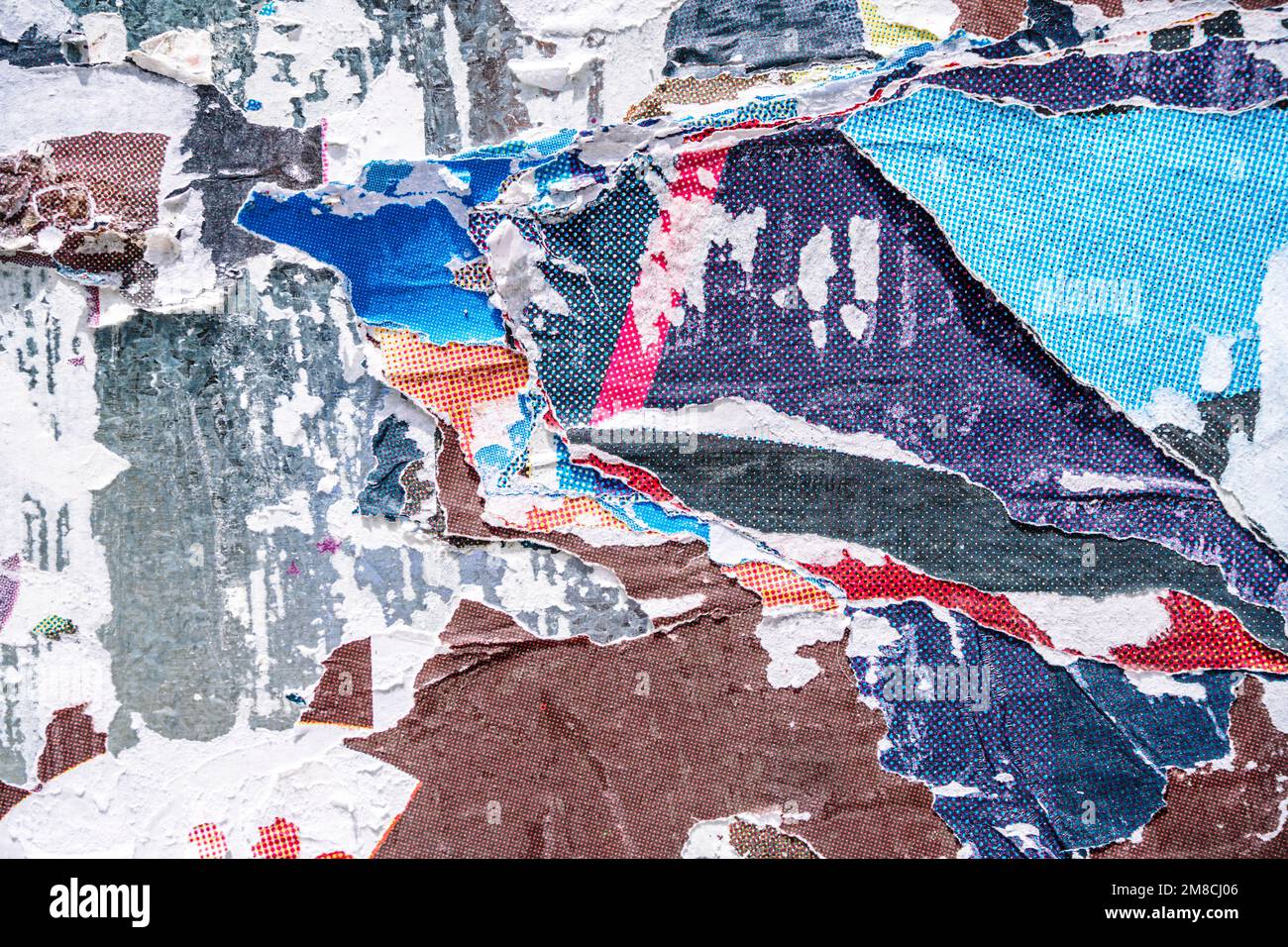 Torn paper collage background on an old poster on a street wall ...