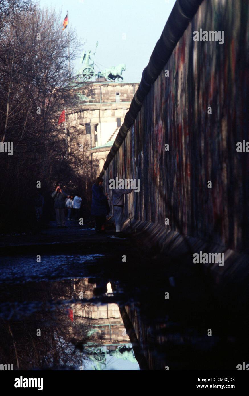 A visitors chips a souvenir fragment from the Berlin Wall near the ...