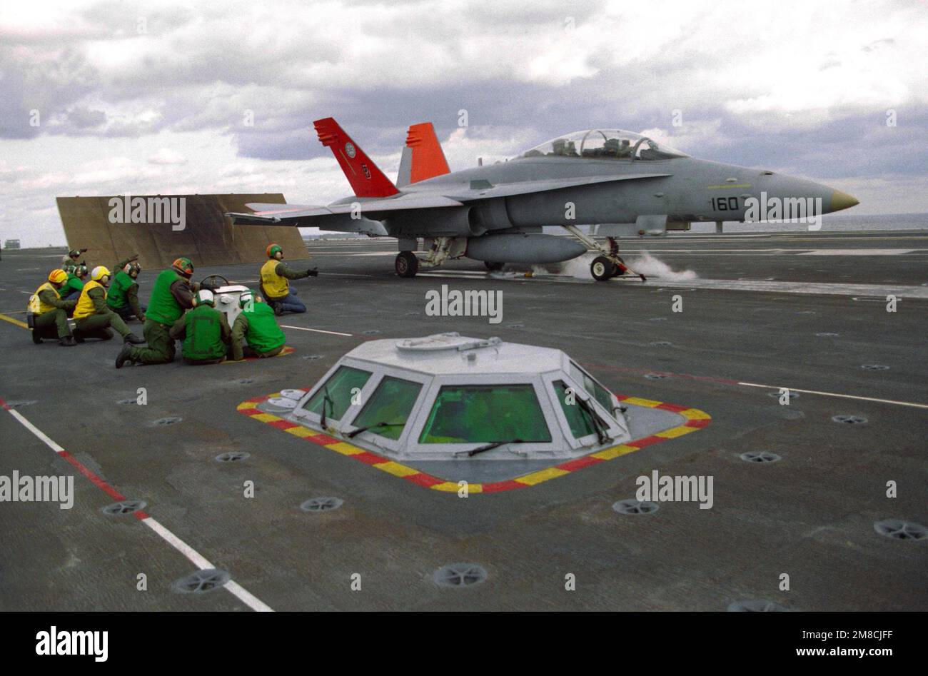 Catapult crew members prepare to launch an F-18A Hornet aircraft from ...
