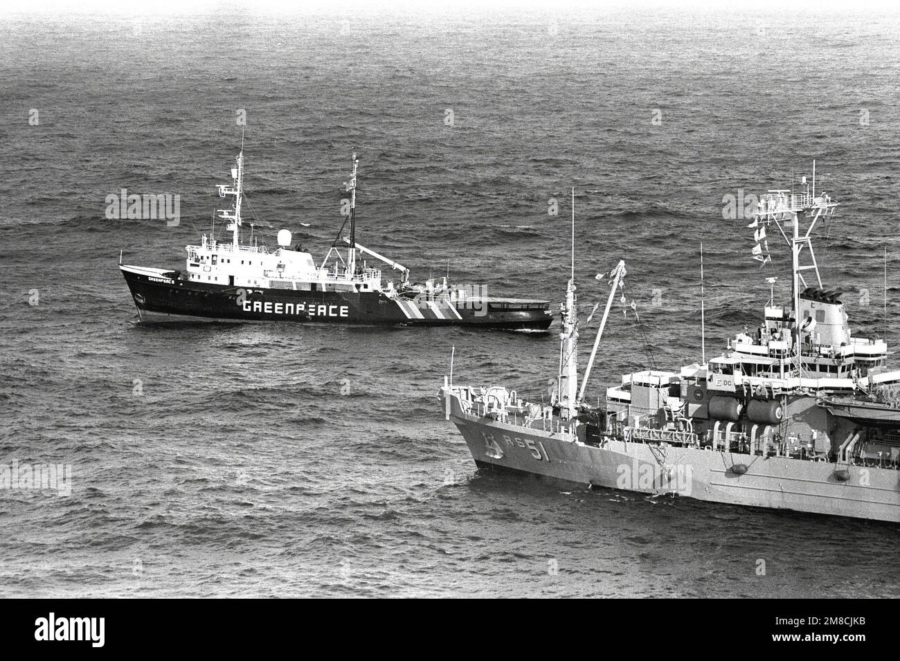The salvage ship USS GRASP (ARS-51) stands off the port side of the ...