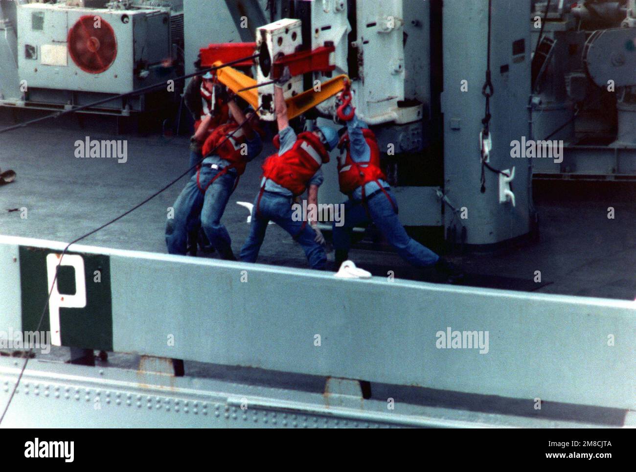 Sailors aboard the ammunition ship USS SANTA BARBARA (AE 28) struggle ...
