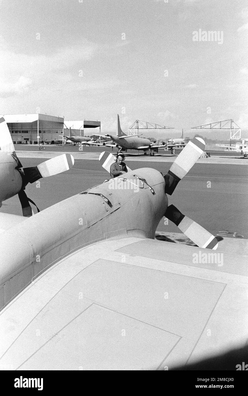 A ground crewman services an engine of a Naval Air Reserve Patrol ...