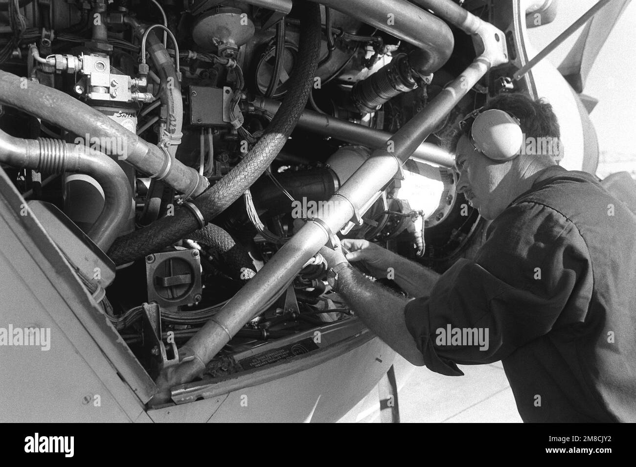 A ground crewman services an engine of a Naval Air Reserve Patrol ...