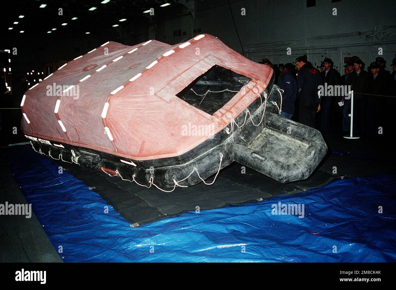Crew members watch as a lifeboat inflates during a demonstration of the ...